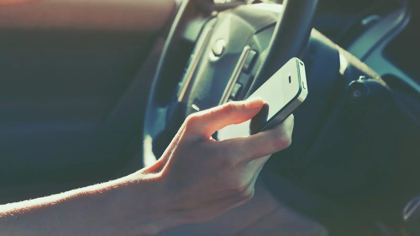 Mão de meninas usando telefone inteligente enquanto carro dirigindo