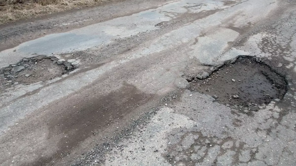 Carretera de asfalto dañada después del invierno.