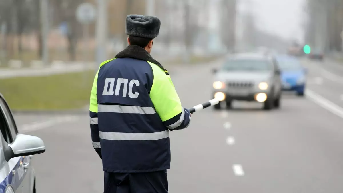 El oficial de policía en forma de oficina detiene el auto.