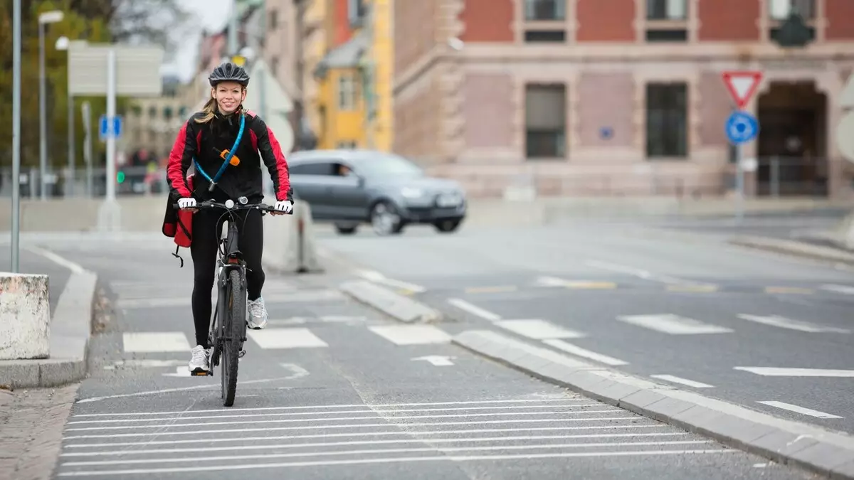 Vroulike fietsryer met koerierafleweringsak op straat