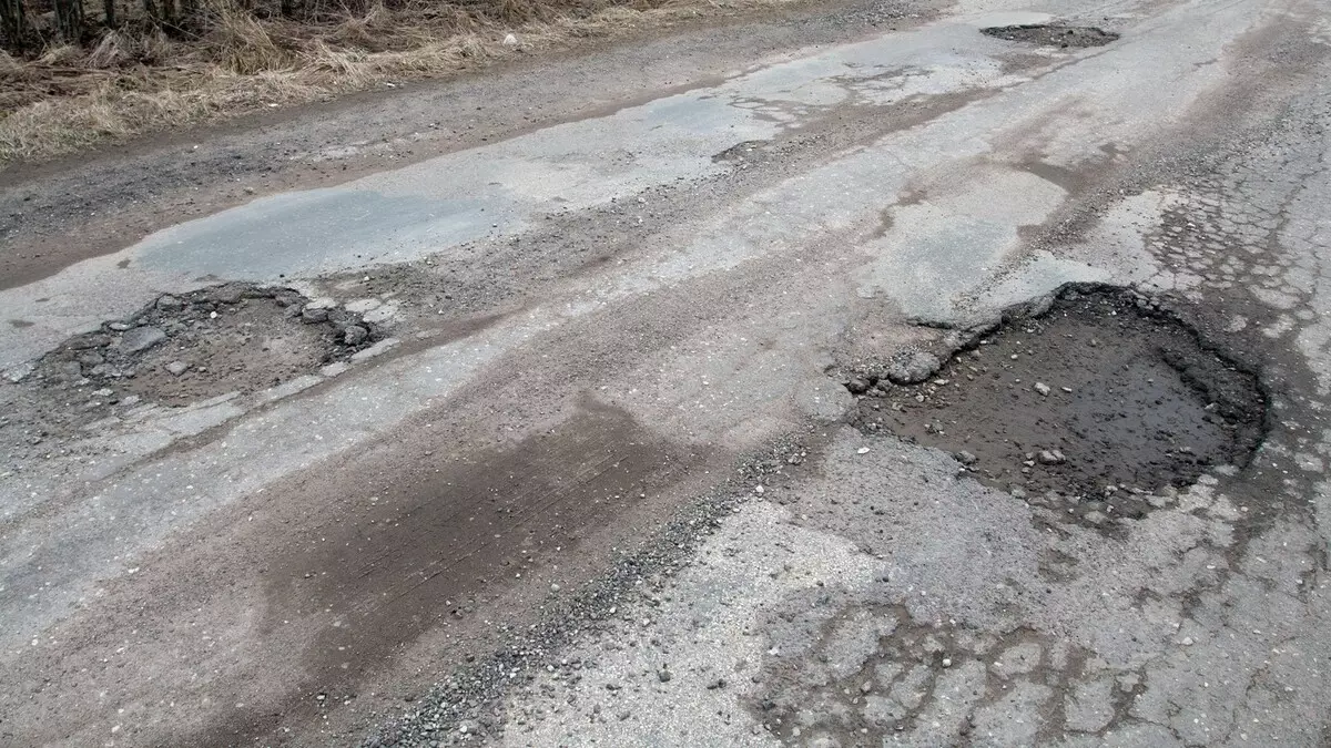 Estrada de asfalto mal despois do inverno.