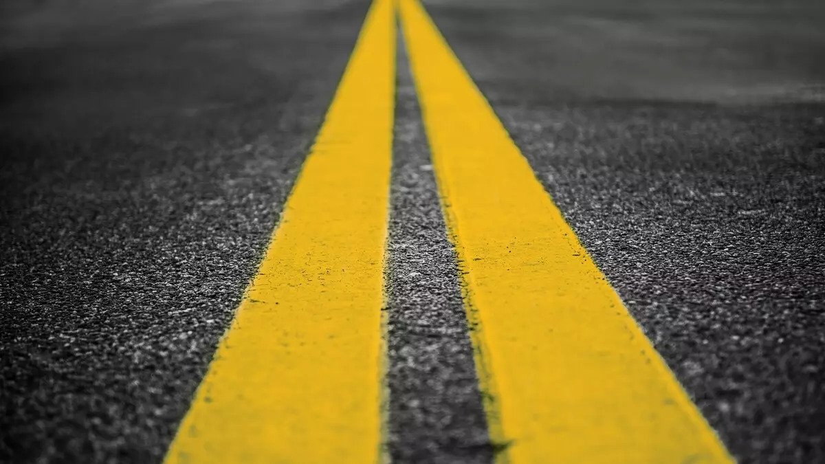 Autoroute asphaltée avec des lignes de marques jaunes sur fond de la route