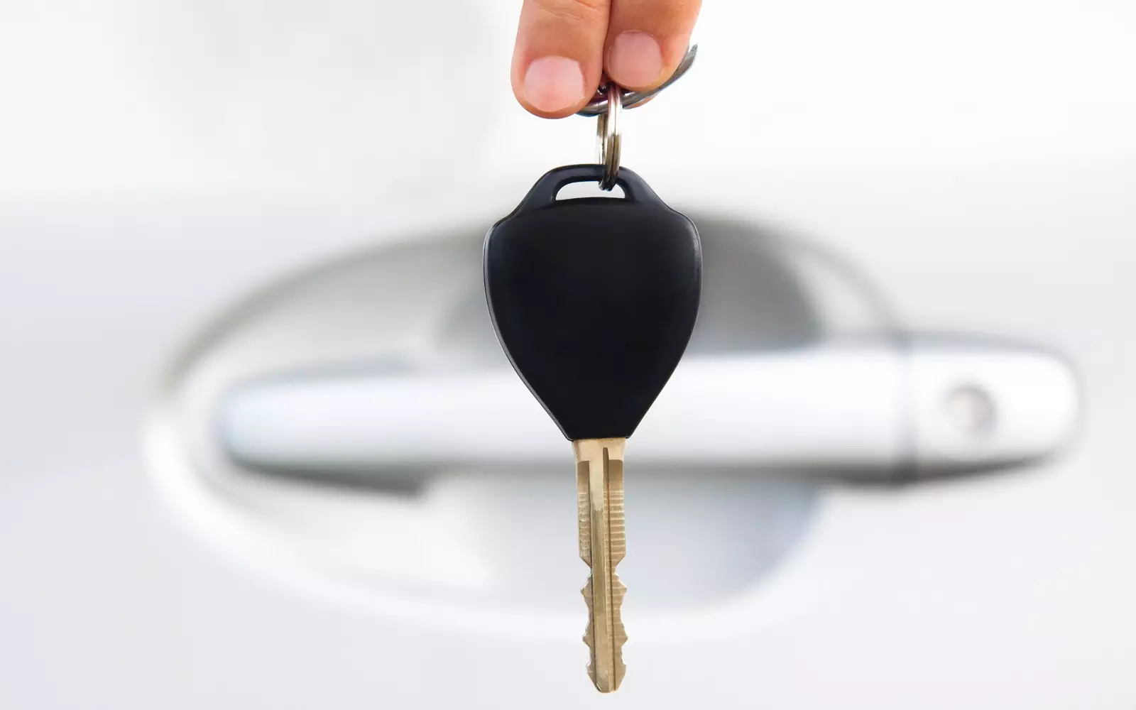Mão segurando a chave do carro antes da porta do carro