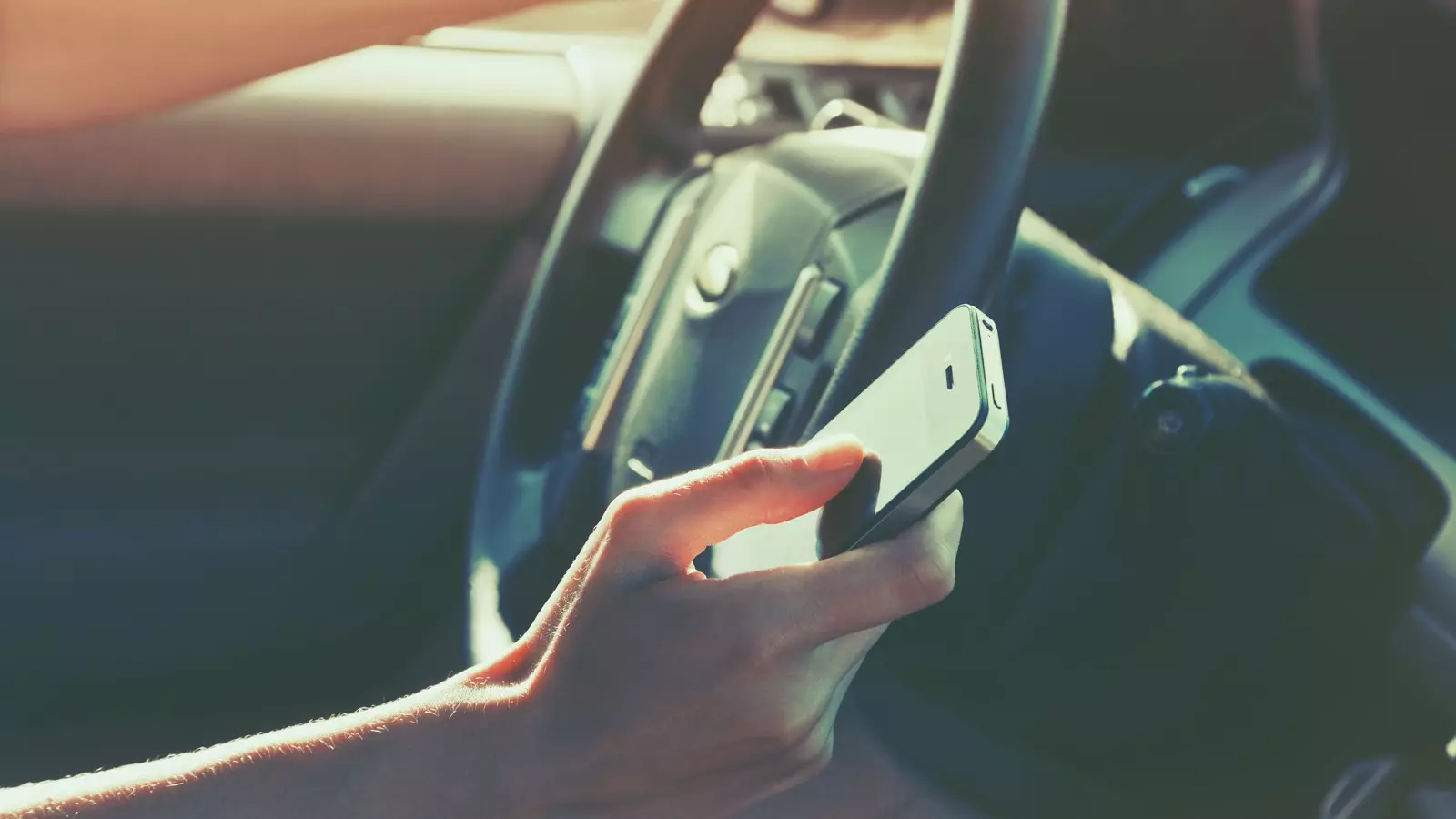 Meisjes hand met behulp van slimme telefoon terwijl auto rijden