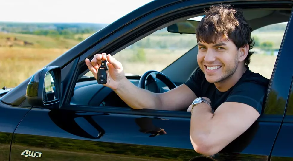 Sretan čovjek koji prikazuje ključeve u automobilu