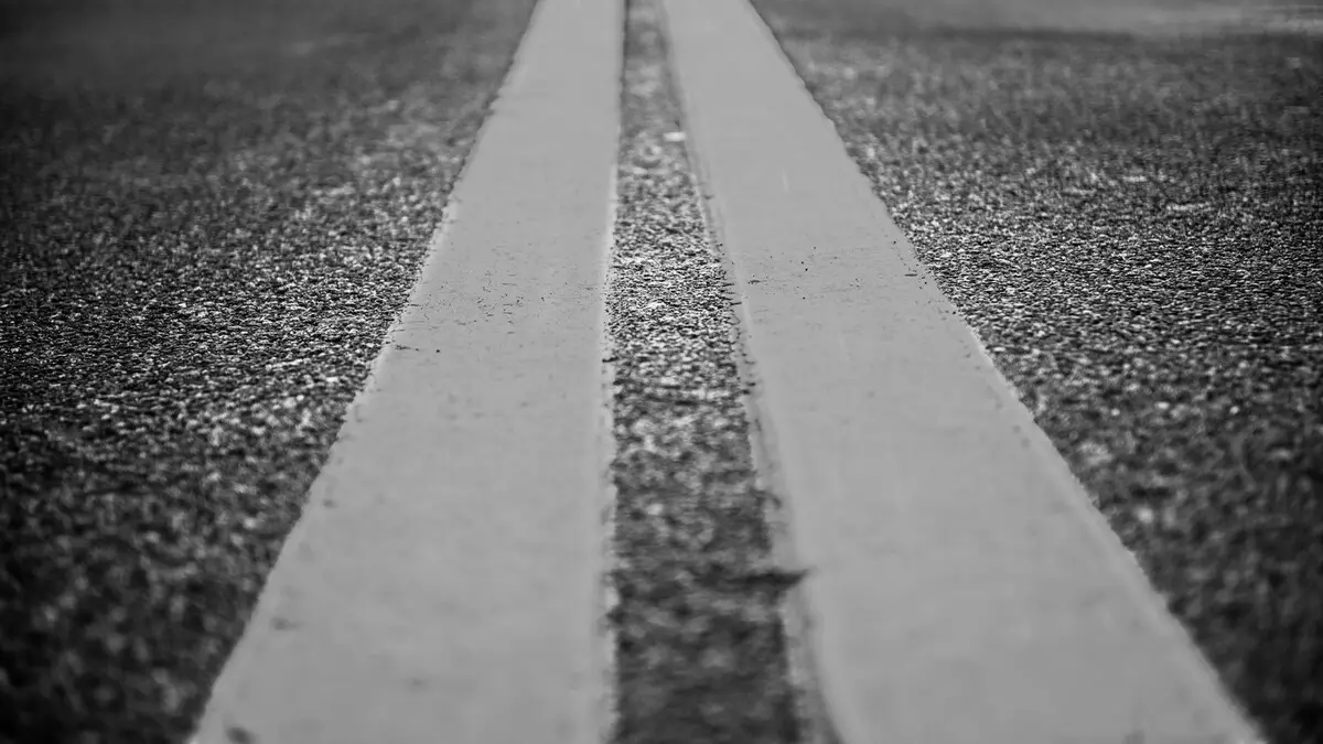 Autostrada dell'asfalto con linee di marcature gialle su sfondo stradale