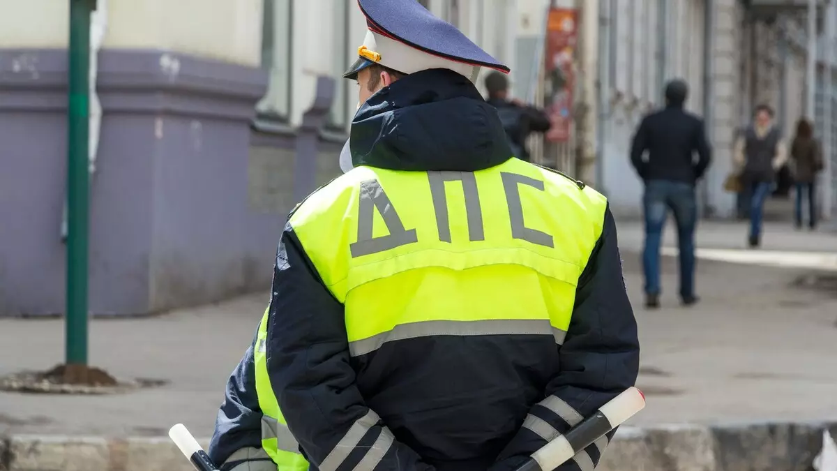 Россиянын полиция кызматкерлери акиташ түстүү формадагы жолдун жанында турушат