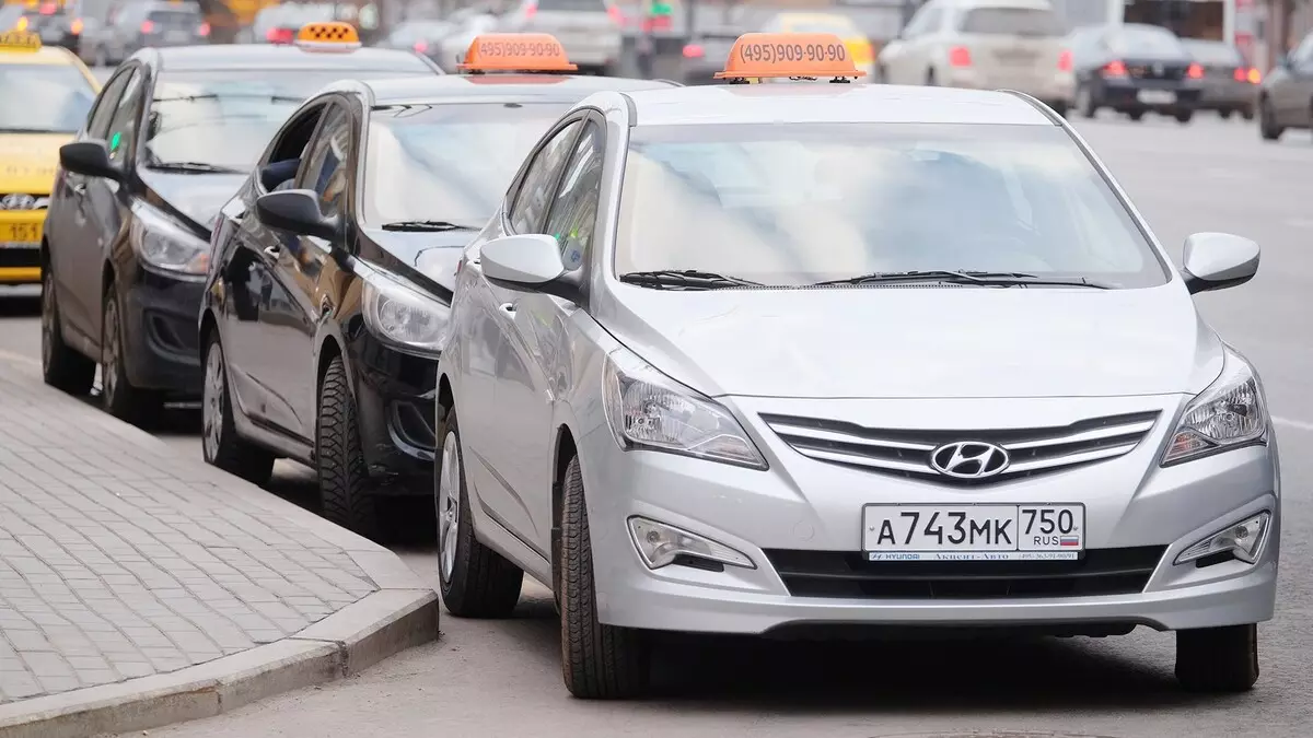 Taksi taksalar ýolagçylara garaşýar. Moskwanyň köçesinde taksi awtoulaglar