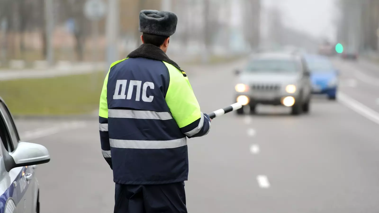 El oficial de policía en forma de oficina detiene el auto.